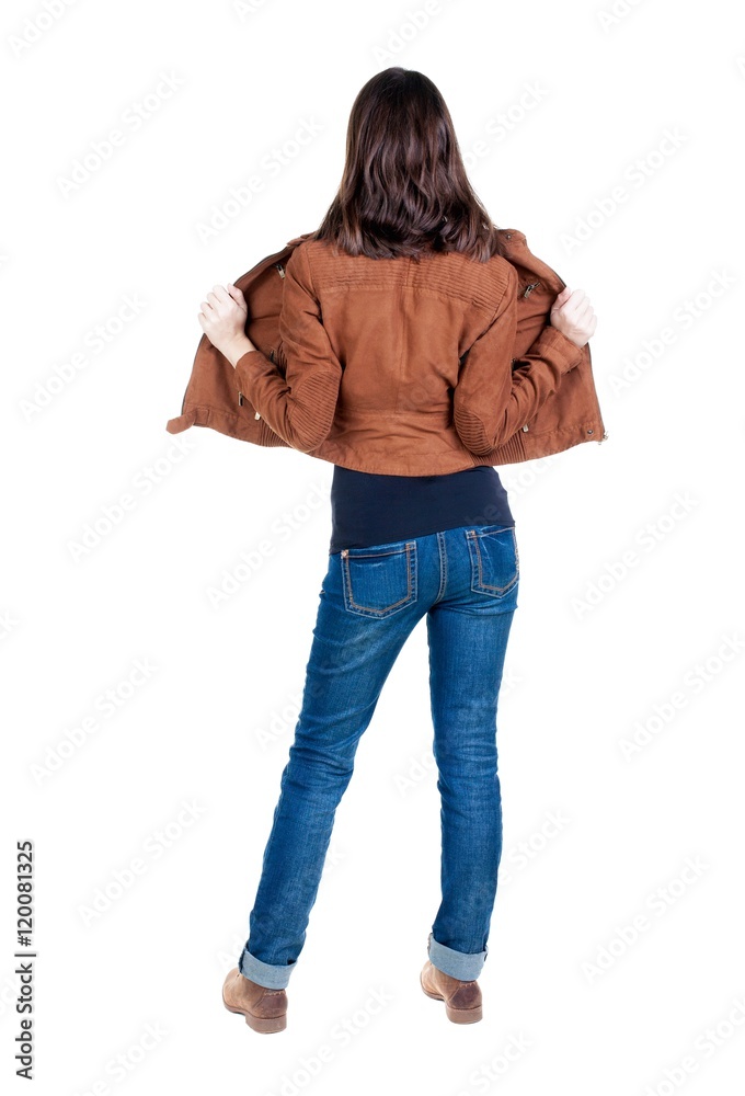 back view of standing young beautiful brunette woman in brown jacket ...