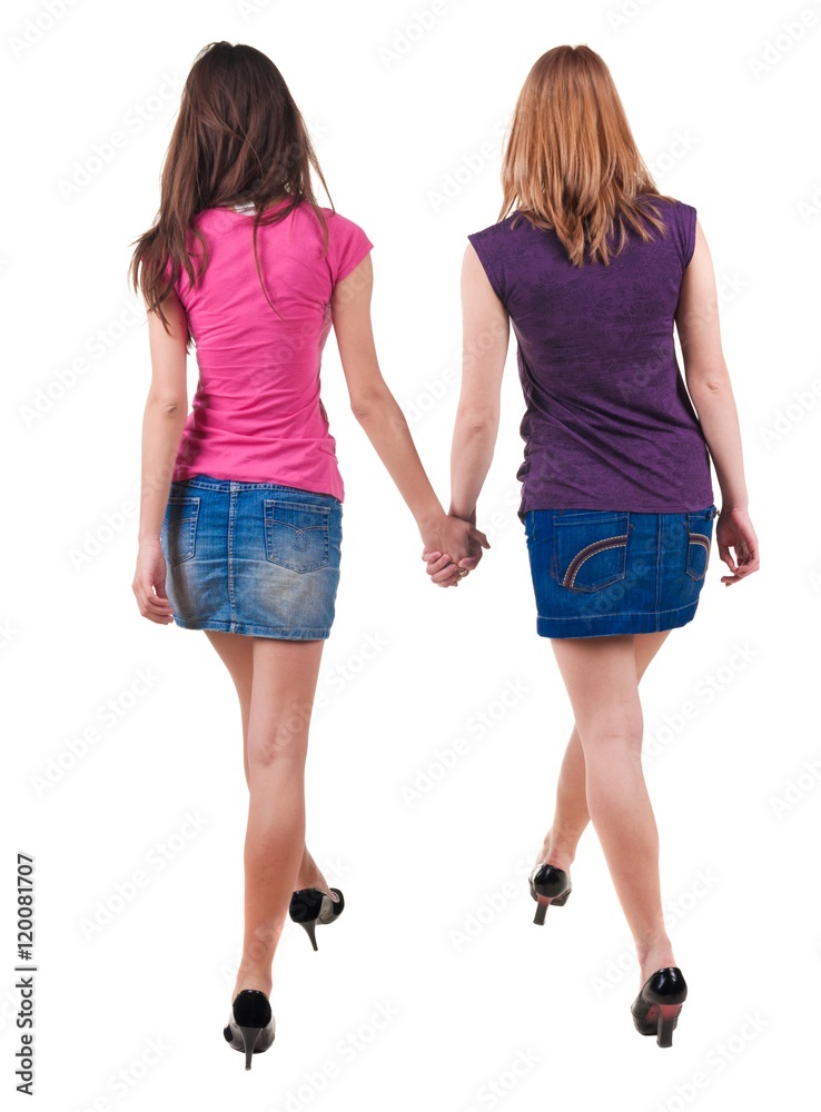 Back view of two young women walking brunette and blonde . Rear view ...