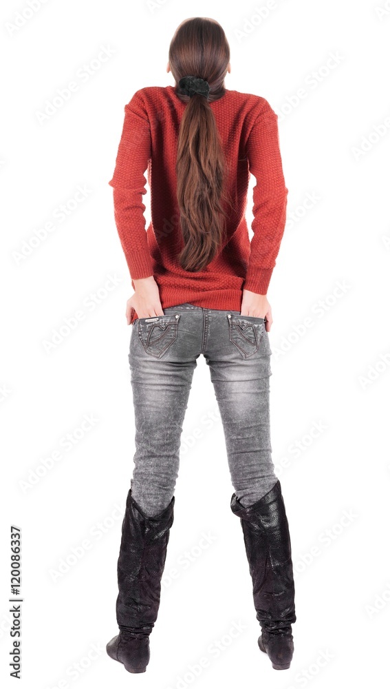 back view of standing young beautiful woman. brunette girl in jeans and ...