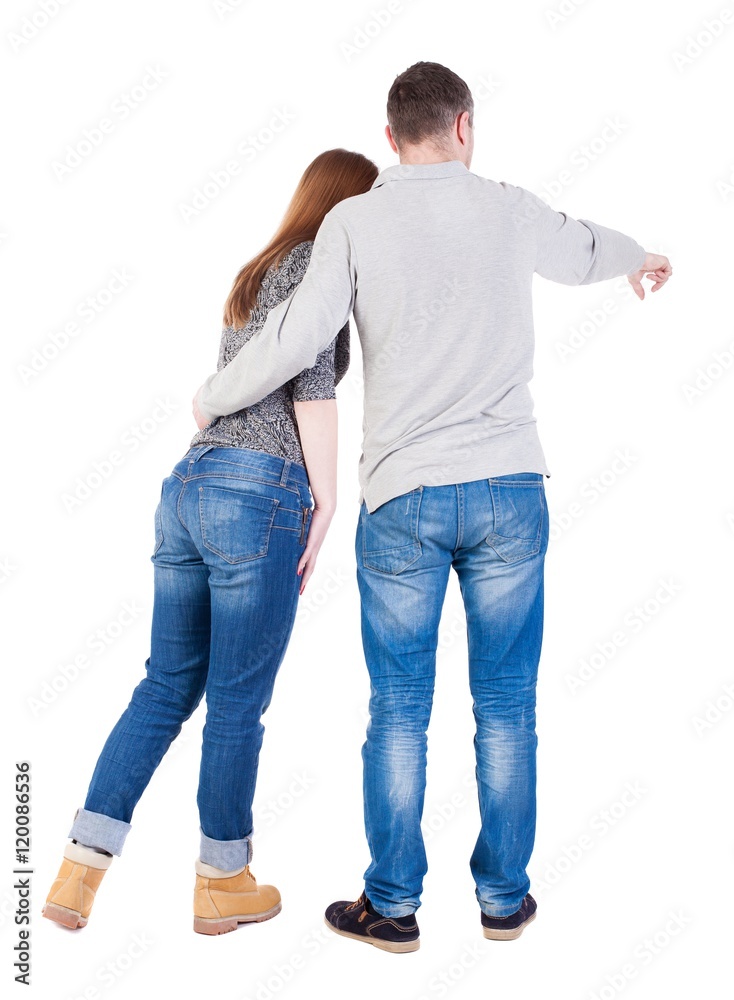 young couple pointing at wal Back view (woman and man). Rear view ...