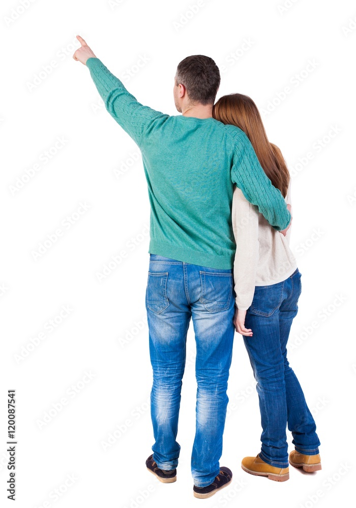young couple pointing at wal Back view (woman and man). Rear view ...