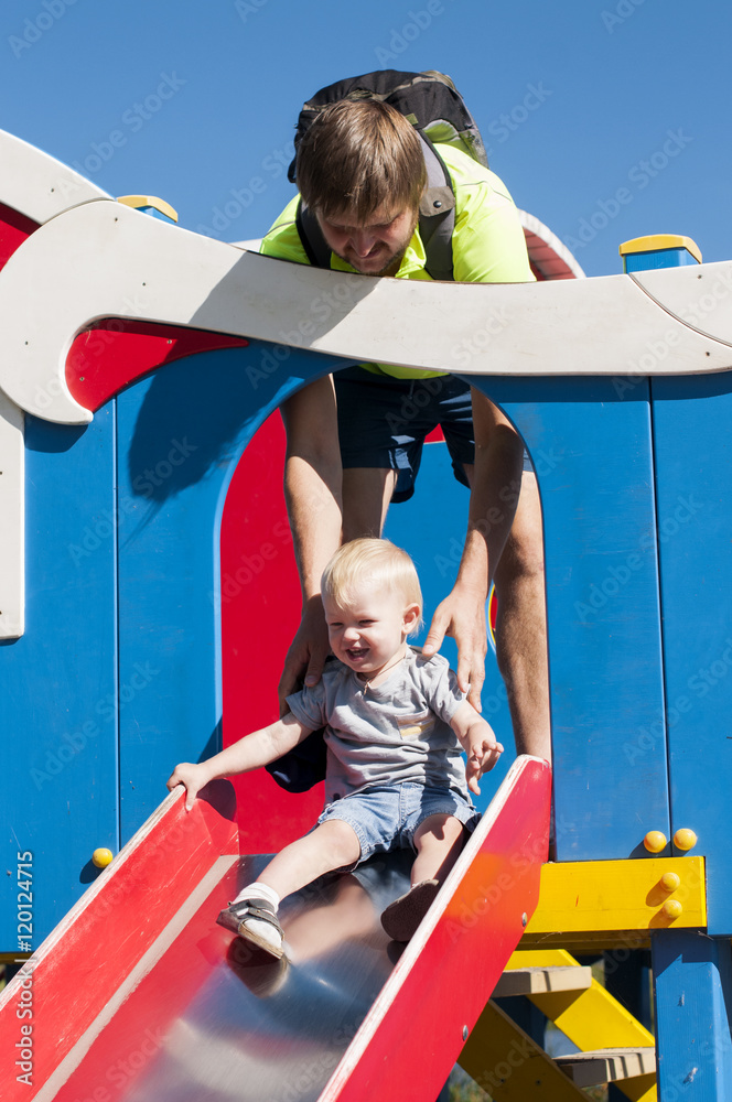 child with his father on slide. Stock Photo | Adobe Stock