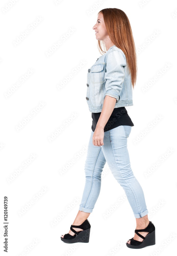 back view of walking woman. beautiful redhead girl in motion. backside ...
