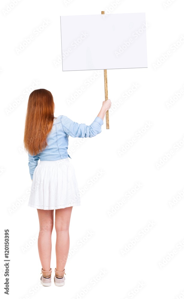 Back view of woman showing a sign board. young redhead girl holds ...