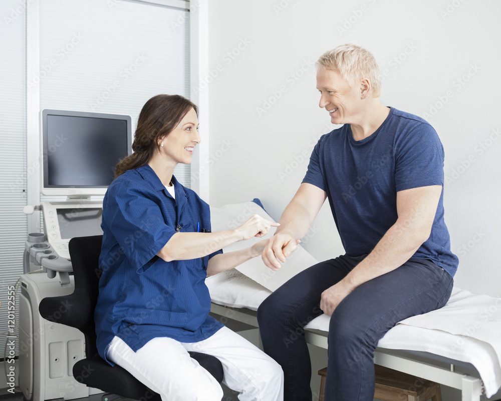 Happy Doctor Touching Male Patient's Hand In Clinic Stock Photo | Adobe ...