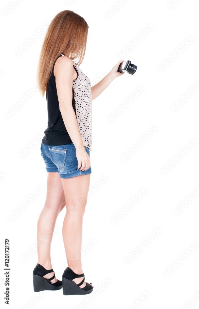 Back view of woman photographing. girl photographer in shorts. Rear ...