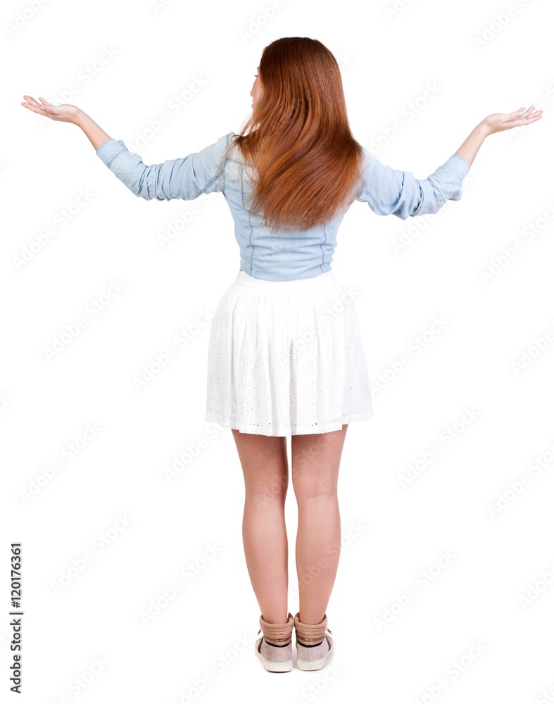 Back view of Beautiful woman in dress looking at wall and Holds hand up ...