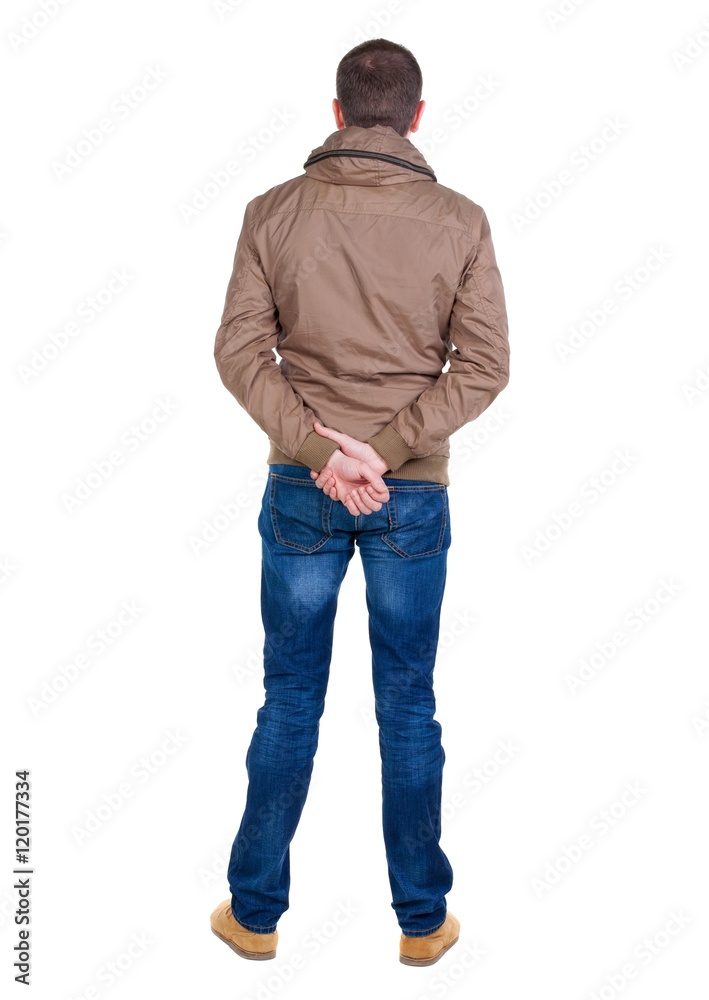 Back view of handsome man in brown windcheater looking up. Standing ...