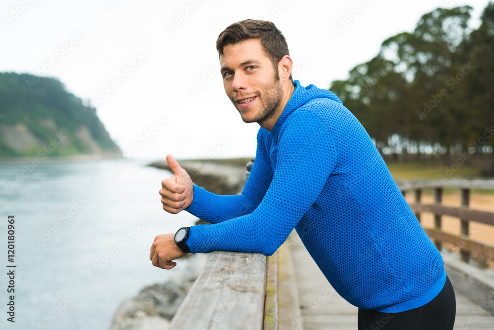 Smiling happy runner man resting during outdoor training workout giving ...