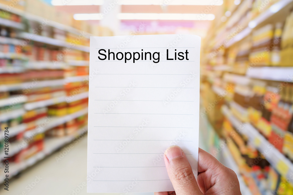 Hand holding shopping list over supermarket blur background Stock Photo ...