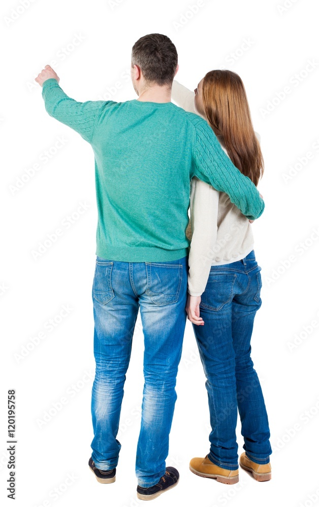young couple pointing at wal Back view (woman and man). Rear view ...