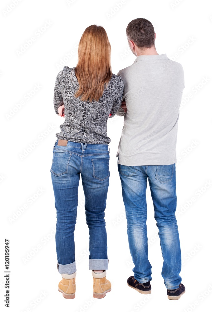 Back view of young embracing couple (man and woman) hug and look into ...