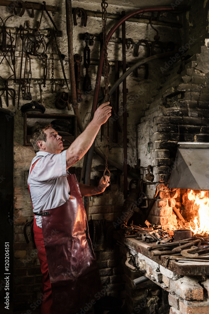 Blacksmith pumping air to kindle fire using bellows Stock Photo | Adobe ...
