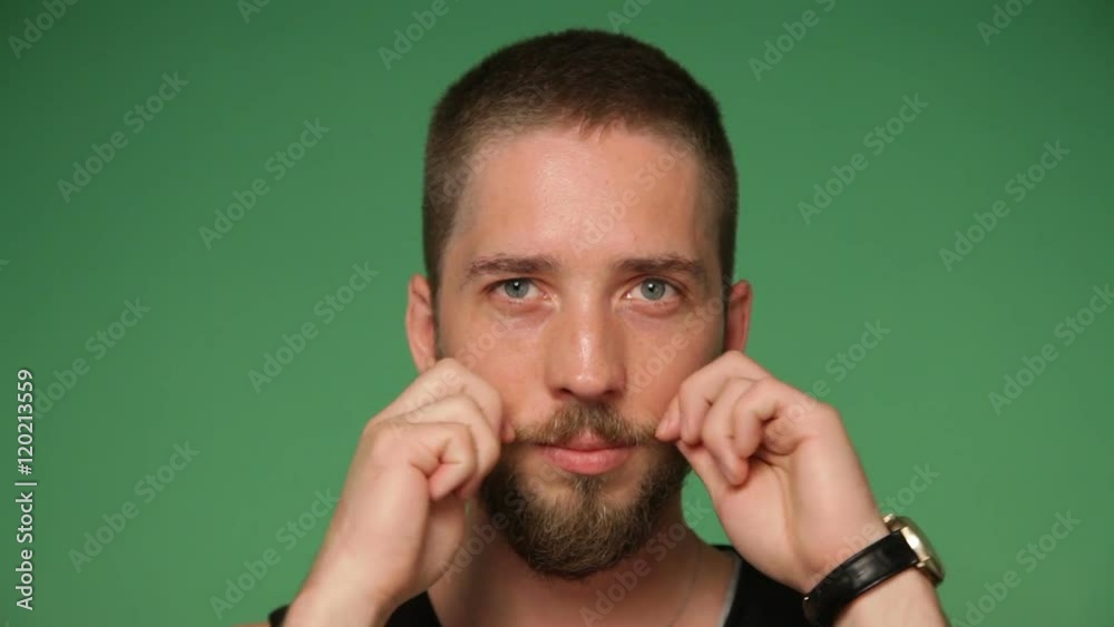 Young trendy man tightening up mustache, green screen background Stock ...