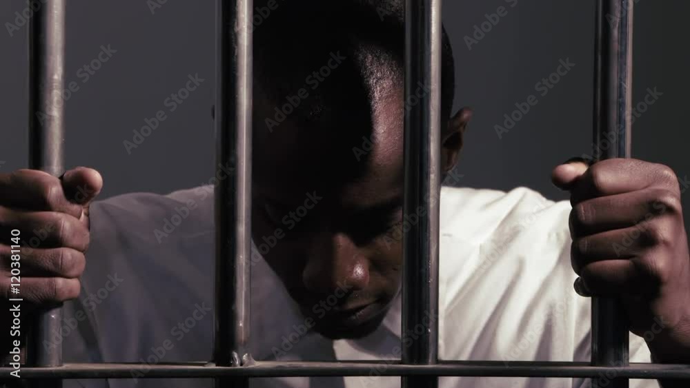 Man in jail behind bars in prison system Stock Video | Adobe Stock