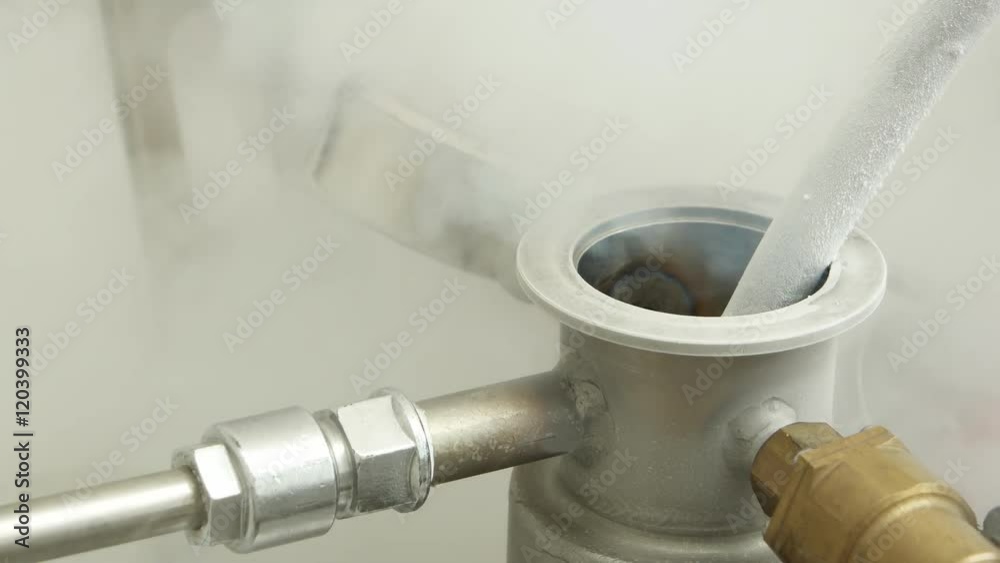 Tank with liquid nitrogen half covered by fume caused by evaporation ...