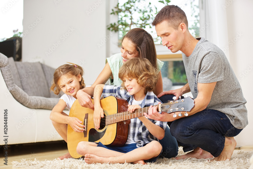 Familie macht zusammen Musik mit Gitarre Stock-Foto | Adobe Stock