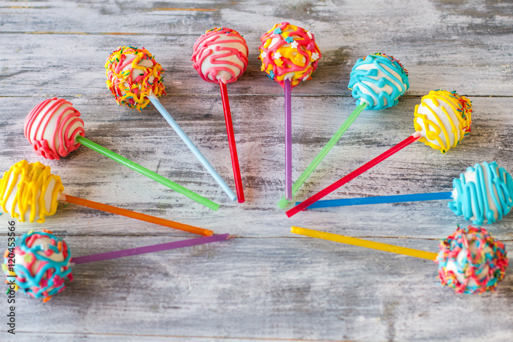 Bright-colored sweets on sticks. Candies with different glaze. Cake ...