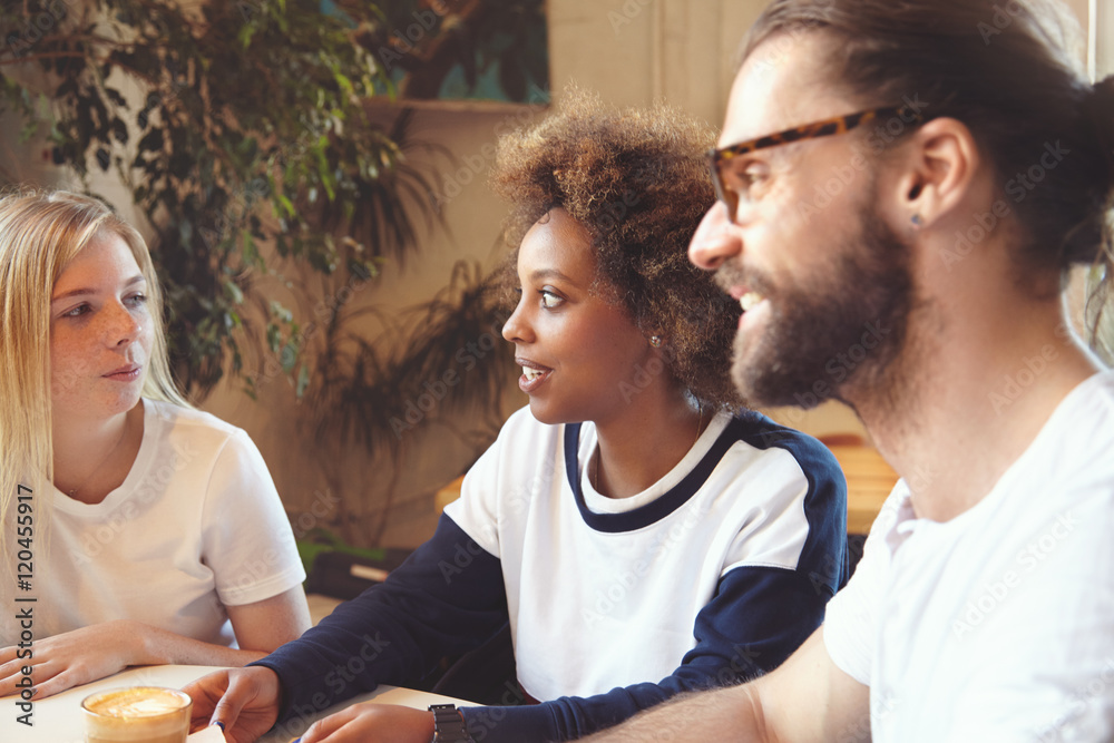 Friendship and communication. Three young students meeting over coffee ...