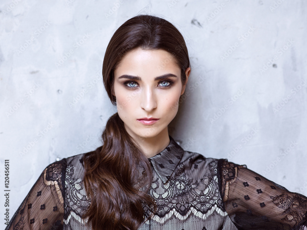 Fashion model wearing black lace shirt and trousers posing in studio ...