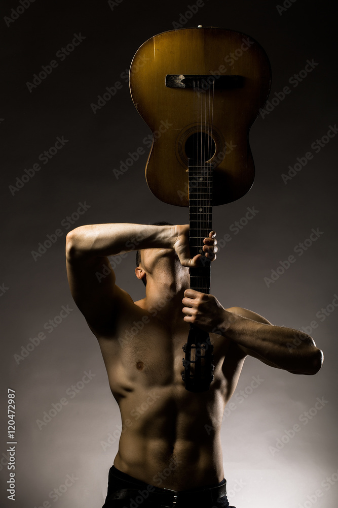 Sexy muscular man with acoustic guitar Stock Photo | Adobe Stock