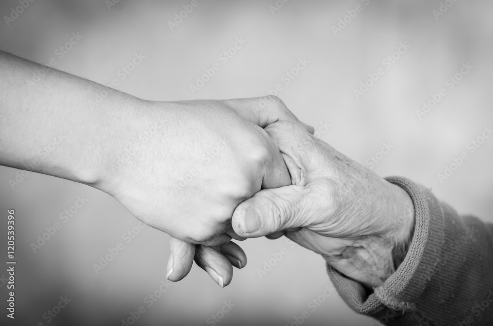 Two People Holding Hands In Black And White