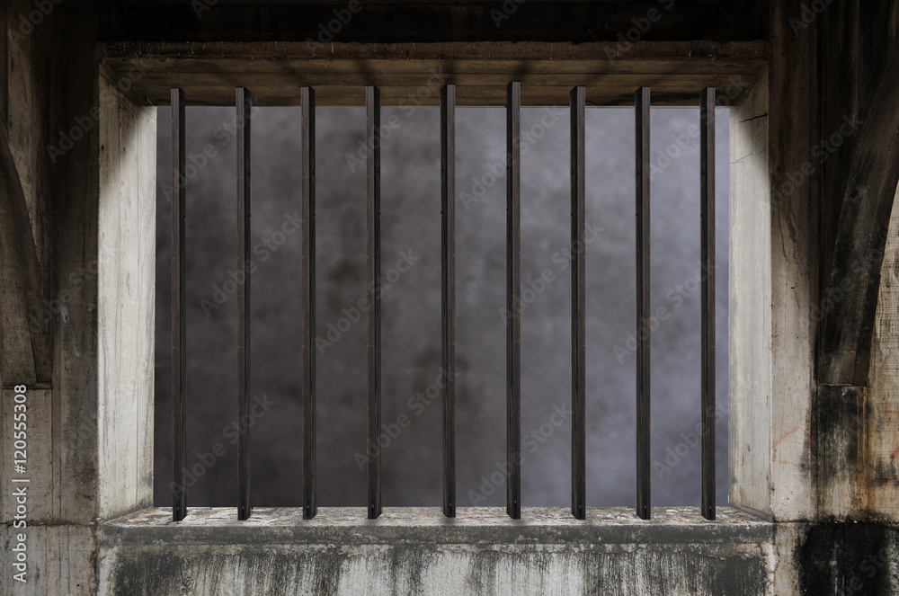 Interior of a prison cell with light shining through a barred window ...