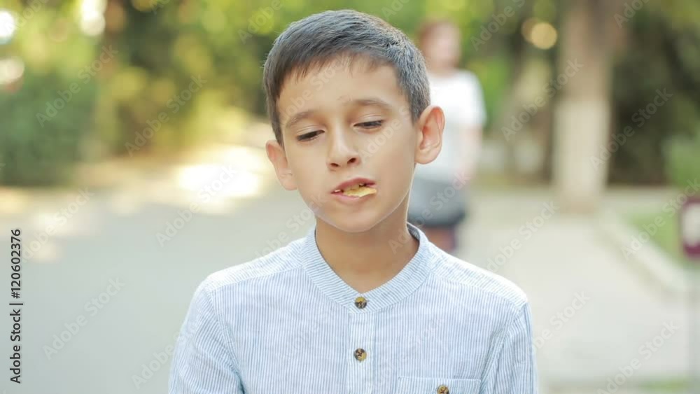 boy eating potato chips on the street. Teen boy eating junk food vídeo ...