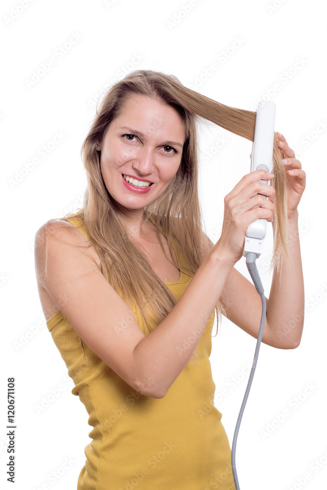 Young woman straightening her hair using hair straightener Stock Photo ...