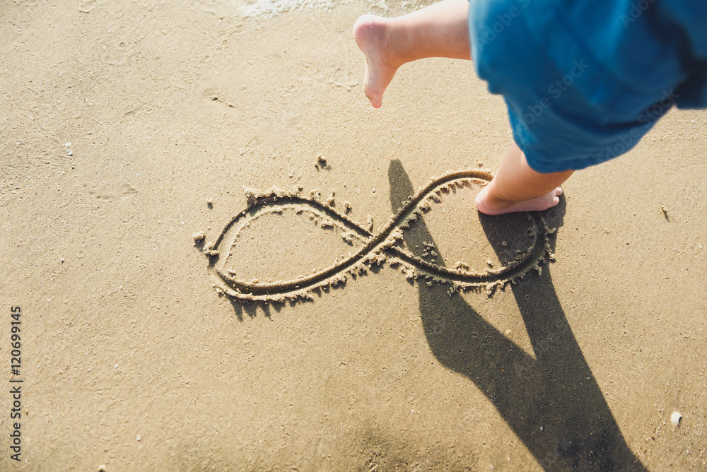 infinity symbol written on sand. Stock Photo | Adobe Stock