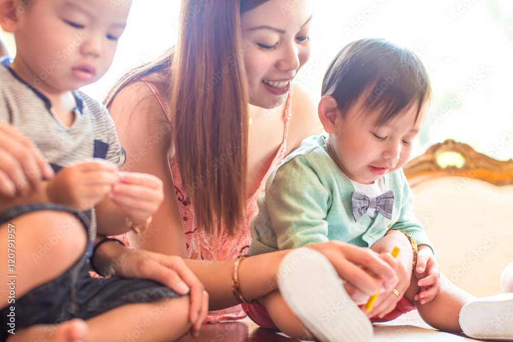 Mother showing crayon drawing to baby boy on dining room table Stock ...