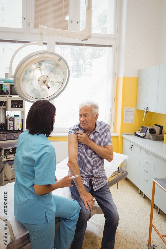Female doctor giving an injection to a patient Stock Photo | Adobe Stock