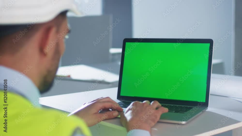 Engineer using Laptop Computer with Green Screen inside Building Under ...