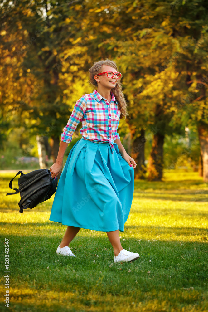 Girl walking with backpack in hands Stock Photo | Adobe Stock