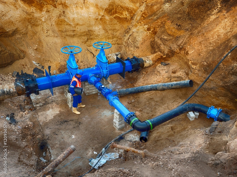 Poster Worker underground at gate valve on drink water system, waga ...