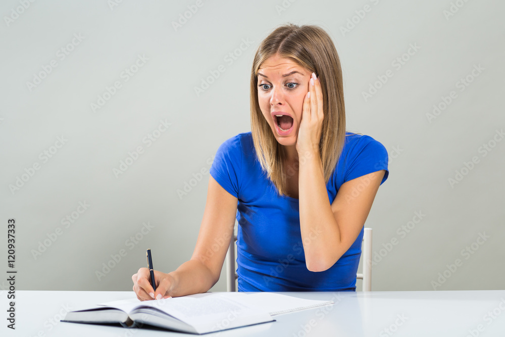 Beautiful female student is in panic because she has got too much to ...