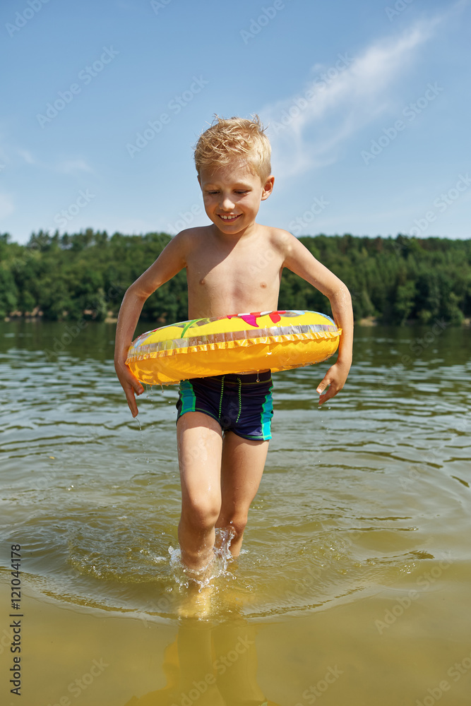Junge beim Baden mit Schwimmring Stock Photo | Adobe Stock