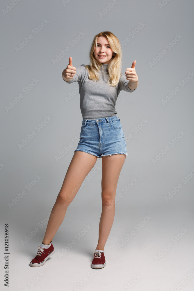 Happy smiling cute young girl showing thumbs up with both hands over ...