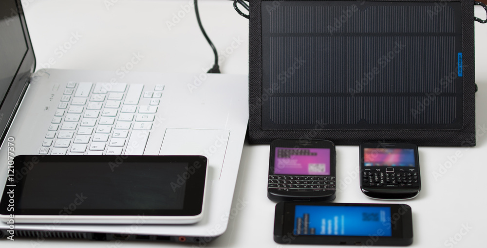 Nice black portable solar charger and tablet sitting next to exclusive ...