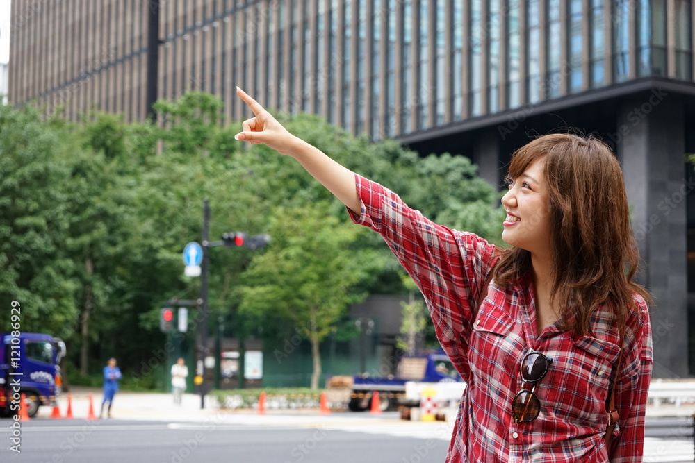 Young Asian woman pointing over there while traveling abroad Stock 写真 ...