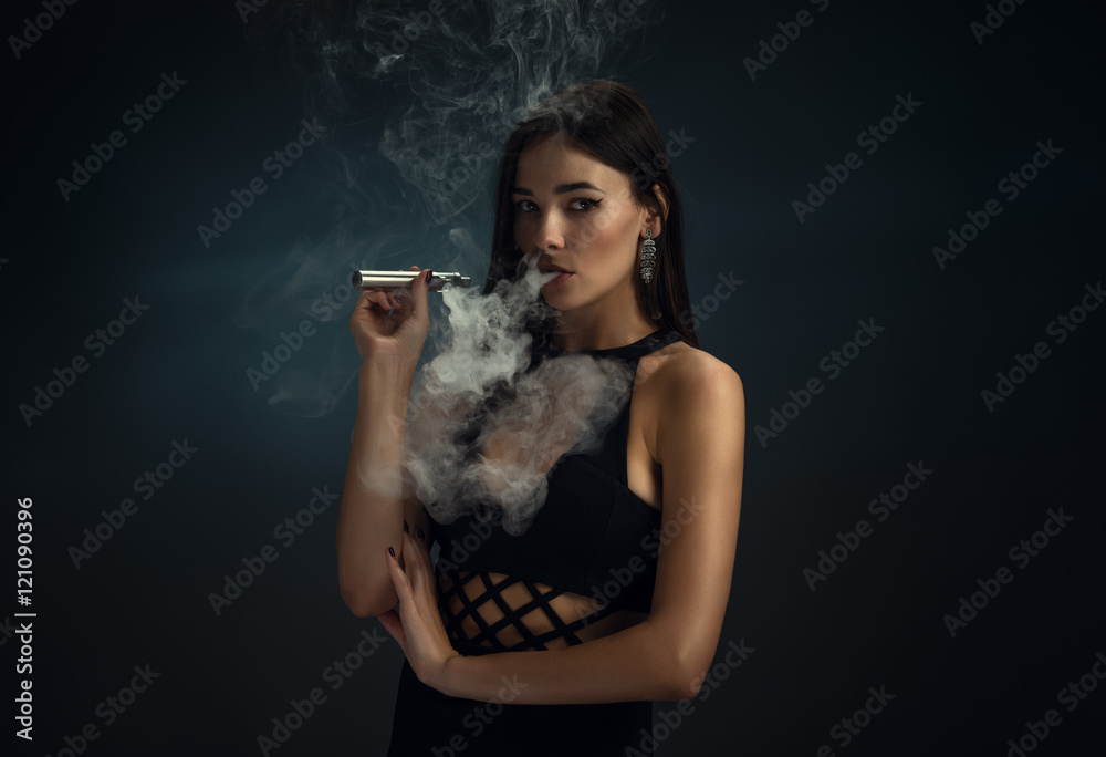 Sexy girl in a black dress smoking electronic cigarette Stock Photo ...
