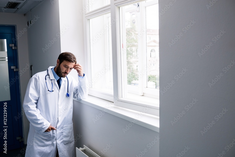 Sad doctor standing in corridor Stock Photo | Adobe Stock
