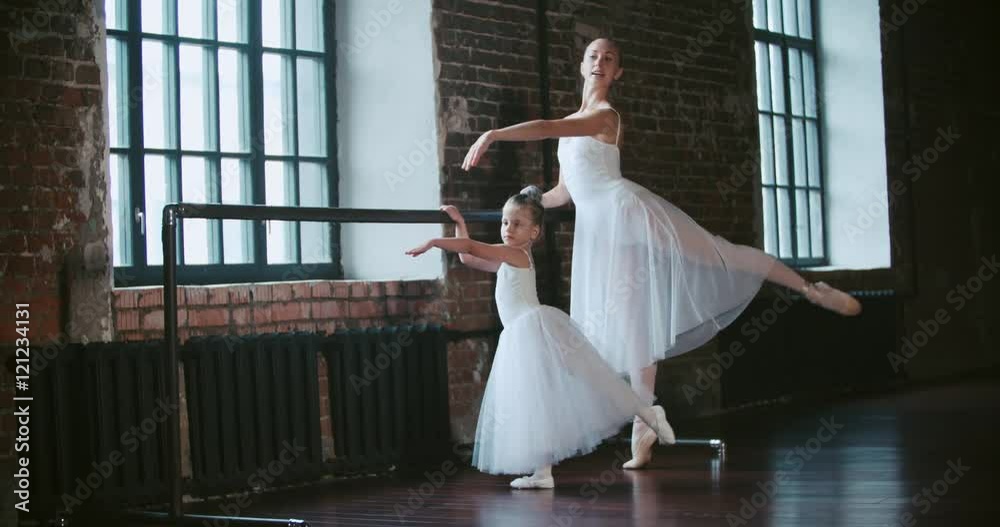 adult ballerina practicing with the little girl and trains her Russian ...