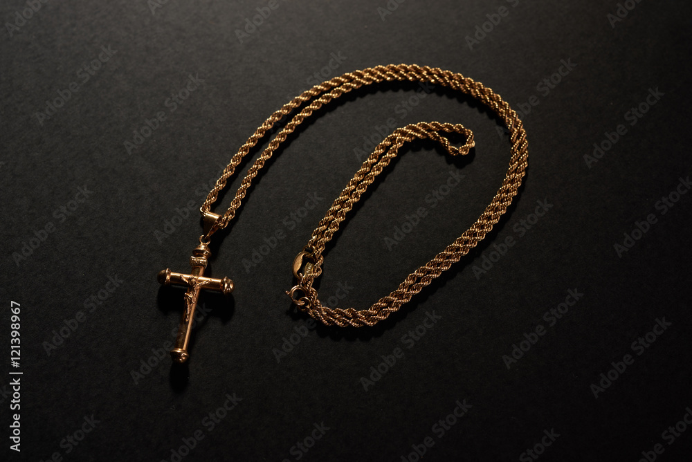 gold cross on a chain on a black background Stock Photo | Adobe Stock