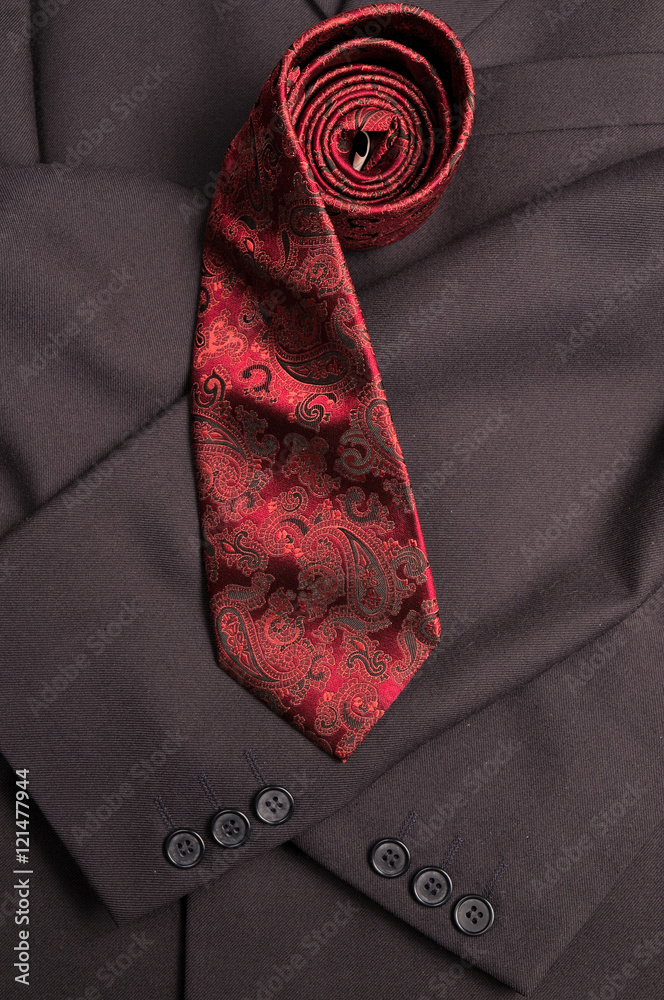 Business suit with a red tie rolled on top. Fashion, executive theme ...