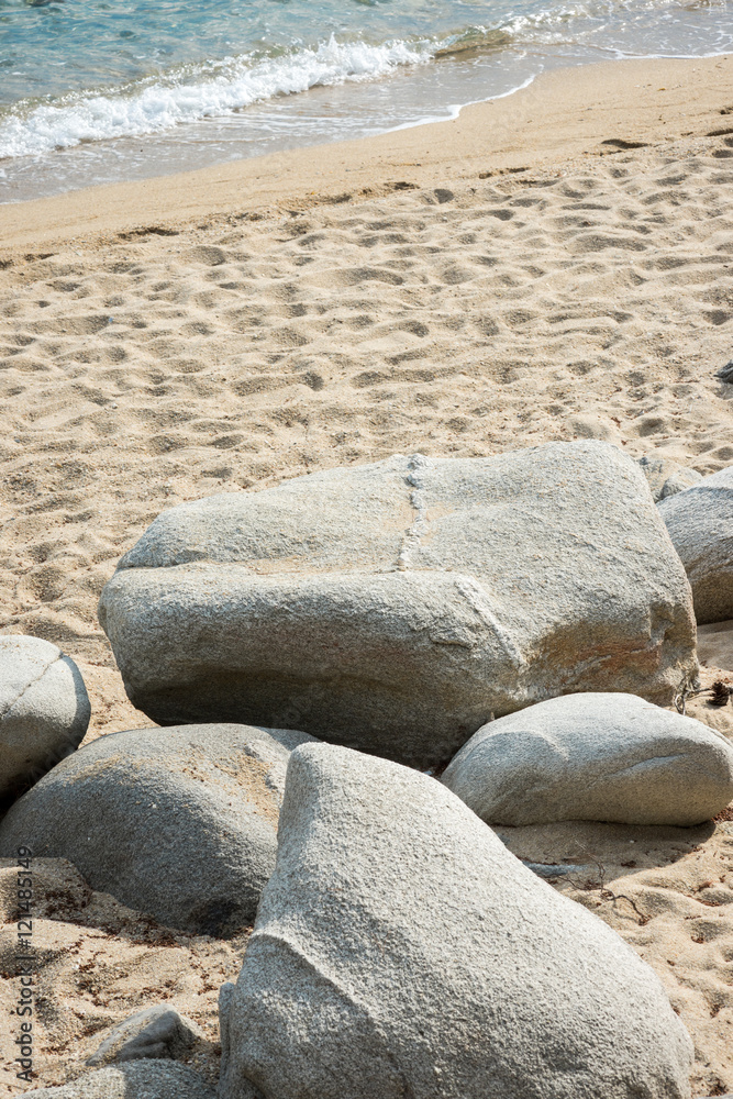 Small rocks scattered on beach sand close up Stock Photo | Adobe Stock