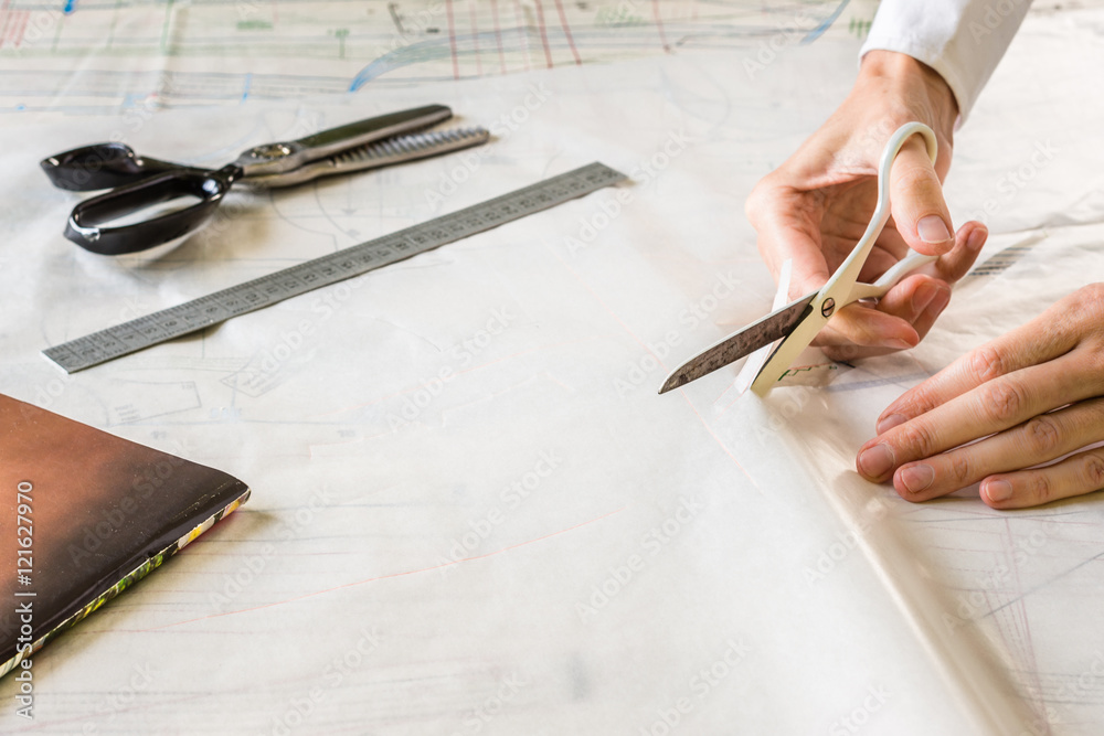 Seamstress is cutting drawing for a dress with scissors. Style and ...
