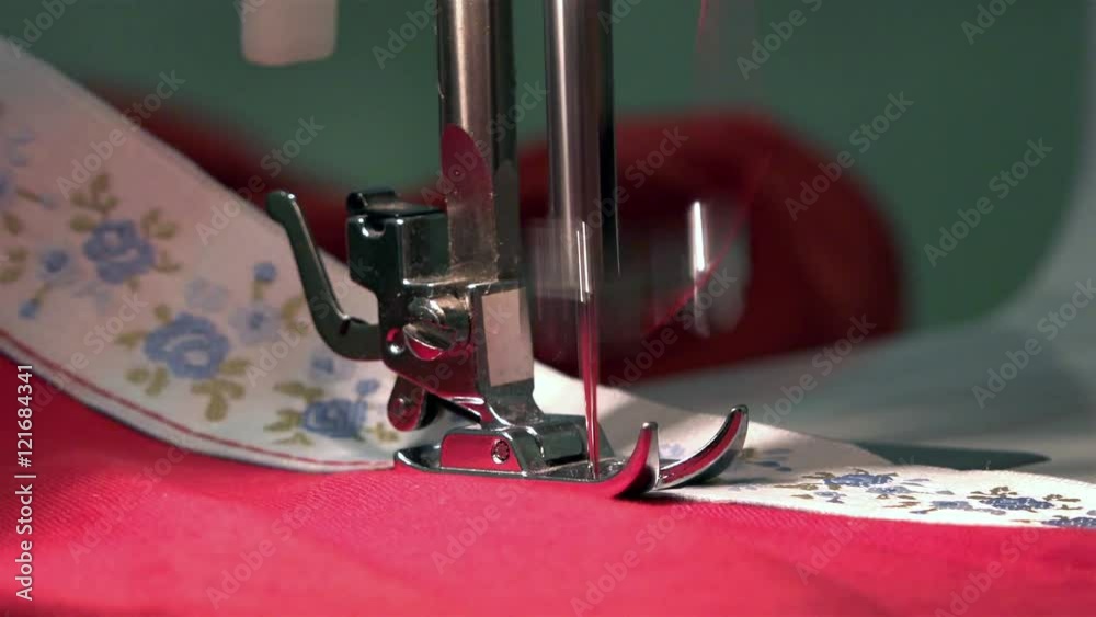 sewing machine needle pierces the elastic tape to the fabric making ...