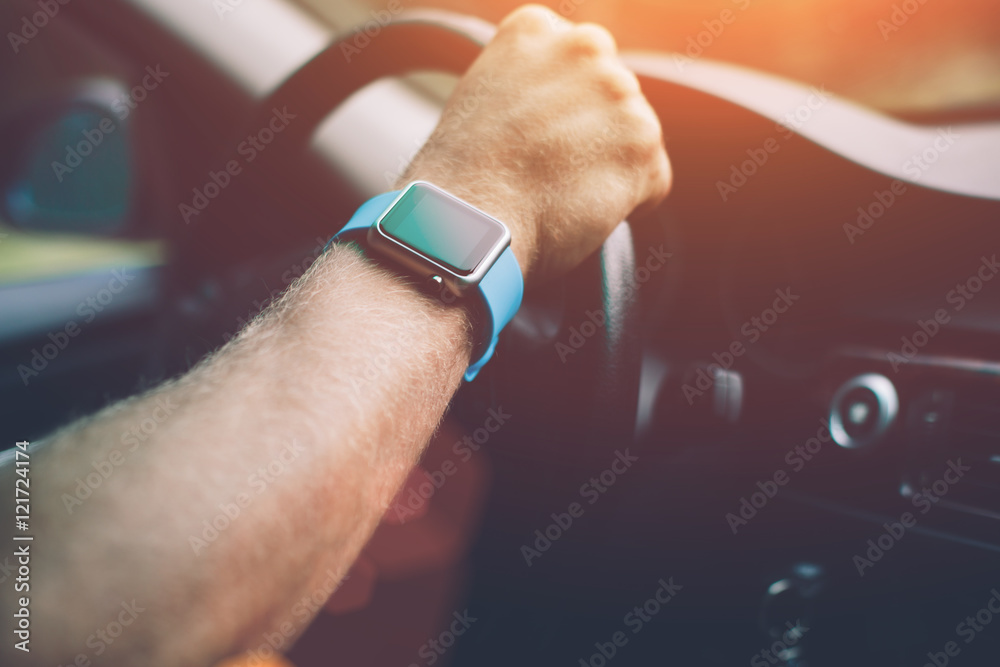 Man driving the car car with smart watch on the arm at sunny day ...