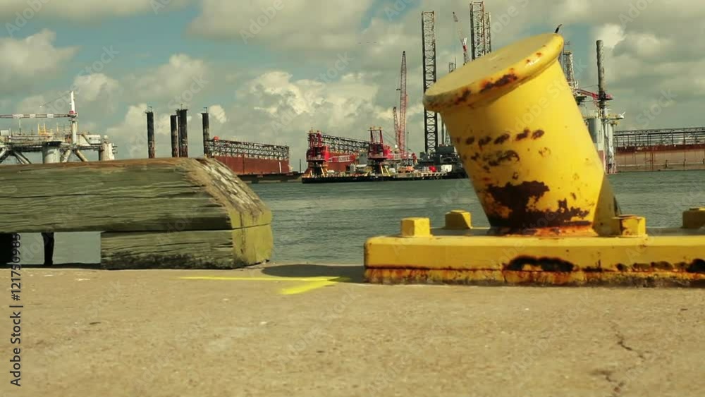 Camera dollies past maritime bollards on a dock to show drilling ...